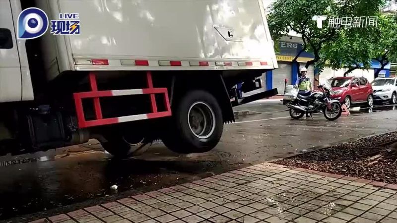 货车被卡树下 进退两难险翻车