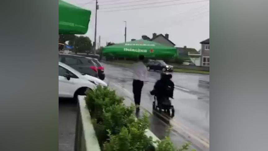 咖啡厅服务员,用他们的遮阳伞互送客户回家。不仅仅是服务到位