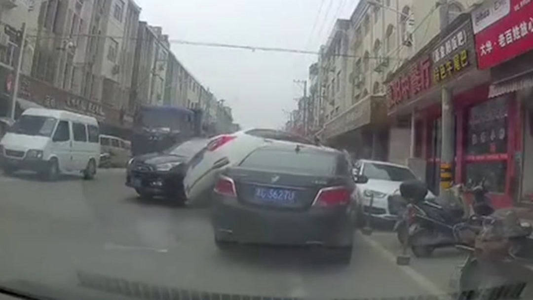 高难度!新手司机上路紧张 一脚油门飞上两车车顶