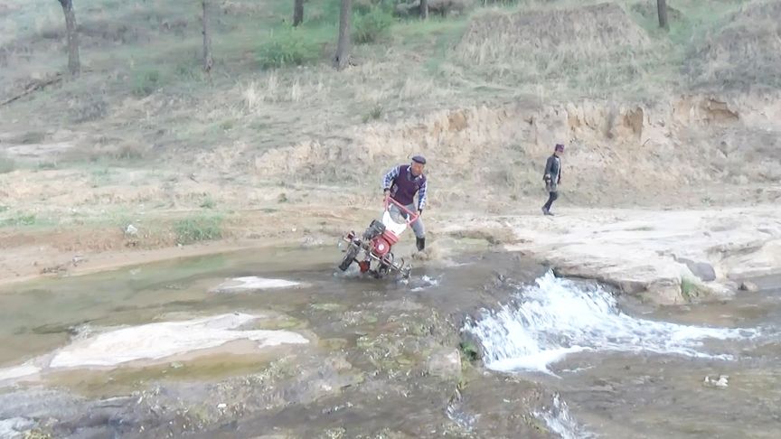 刘四二哥买的二手刨刨机,推在地里翻地,路上差点掉河沟里