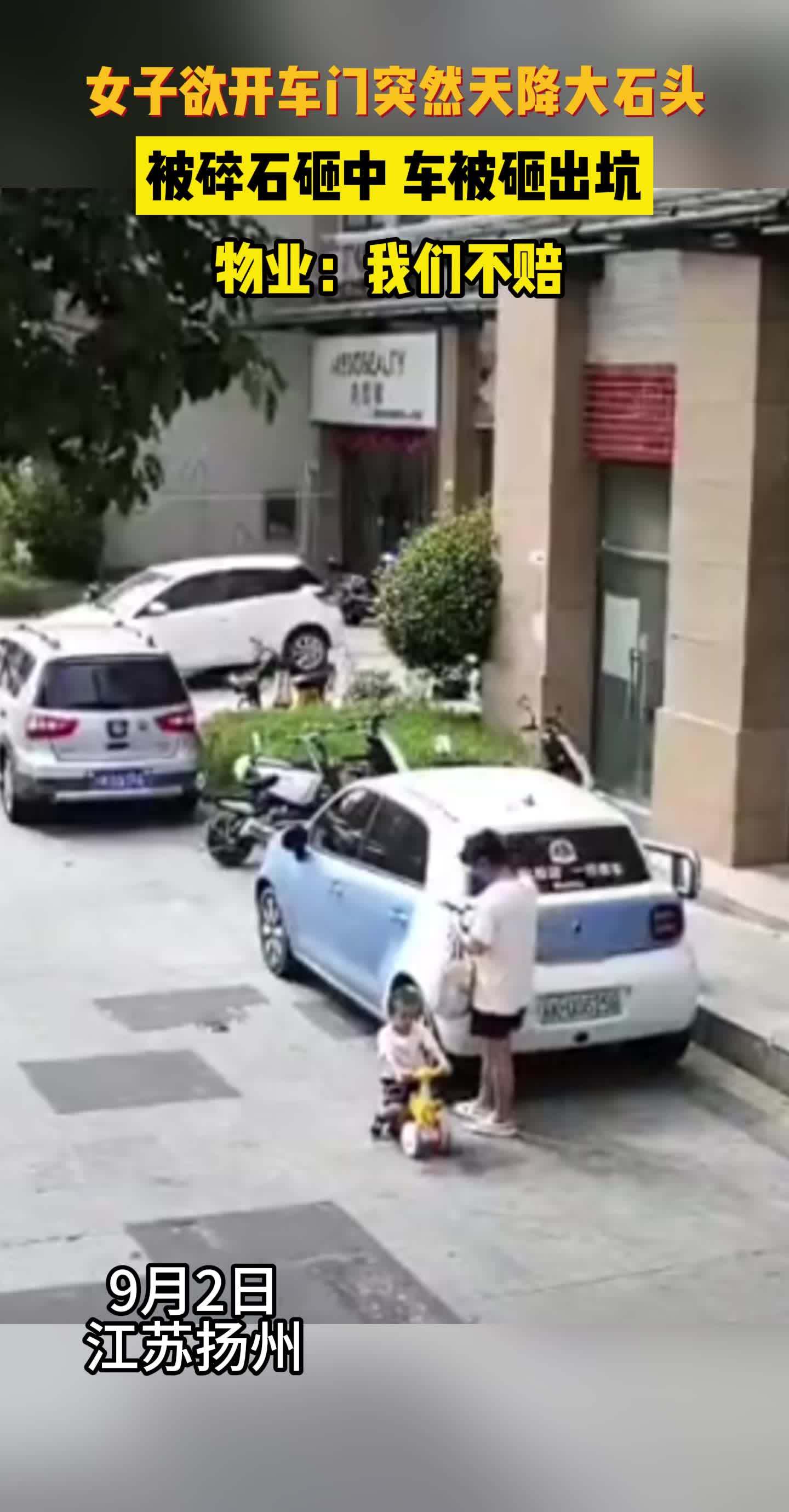 女子欲开车门突然天降大石头,被碎石砸中 车被砸出坑