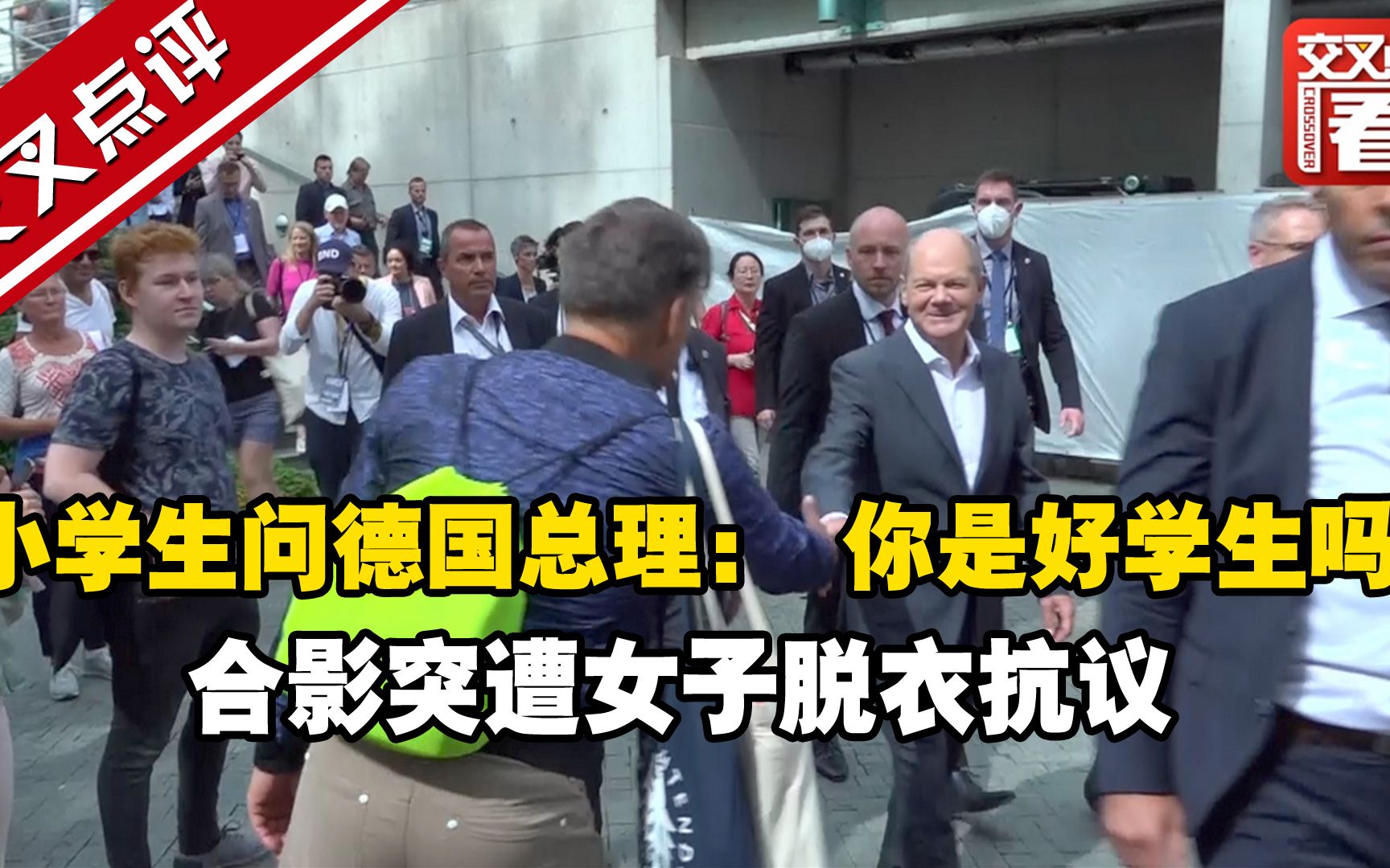政府开放日 小学生问德国总理: 你是好学生吗?. 合影突遭女子脱衣抗议
