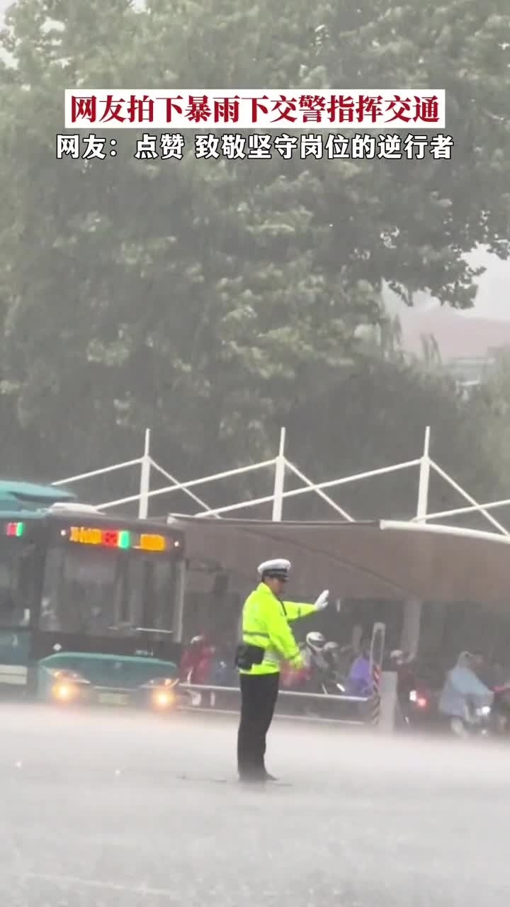 7月12日,山东济南,网友拍下暴雨下交警指挥交通。
