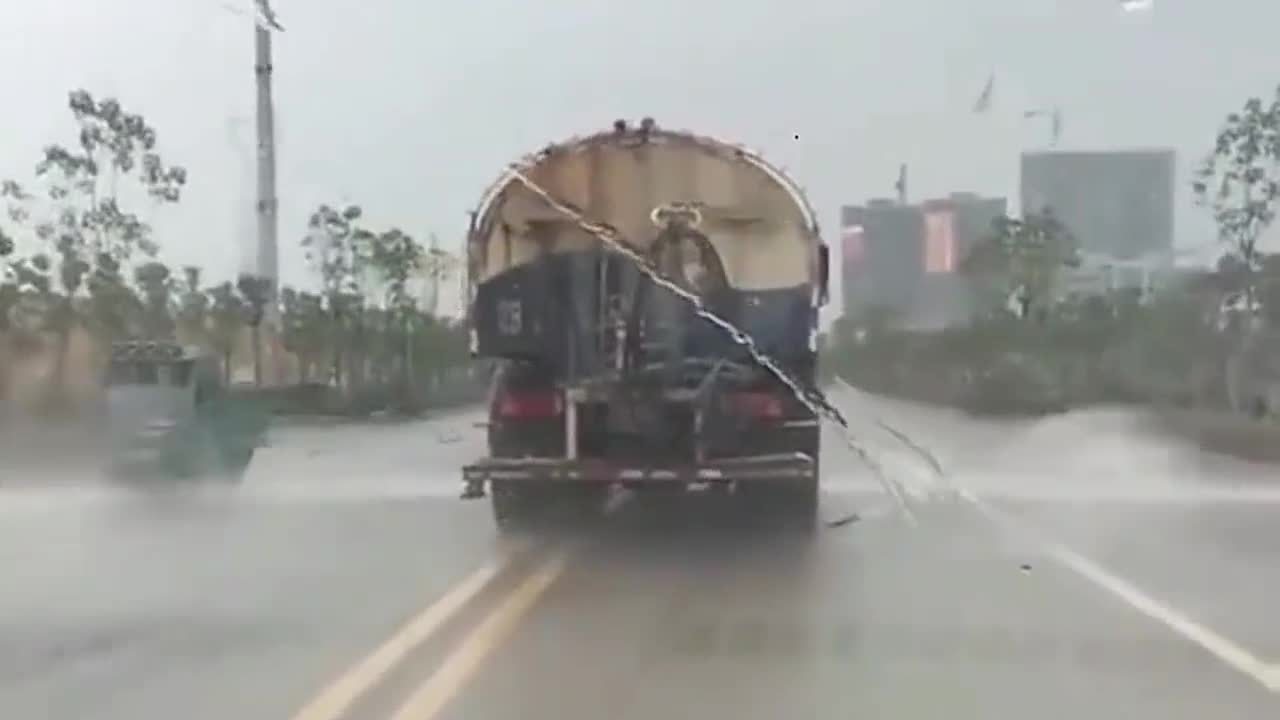 这城市洒水车师傅真会玩,后面小车驾驶员拍下全过程