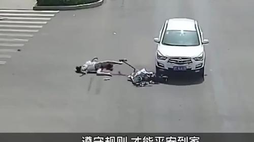 心疼孩子,监控拍下家长骑车不戴头盔带小孩闯红灯