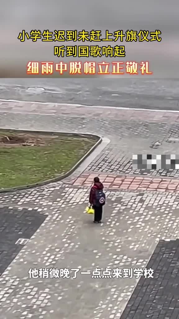 小学生上学迟到未赶上升旗仪式,国歌响起时,在细雨中脱帽立正敬礼