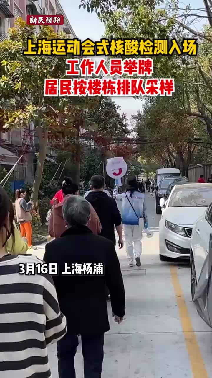 上海运动会式核酸检测入场。工作人员举牌,居民按楼栋排队采样。
