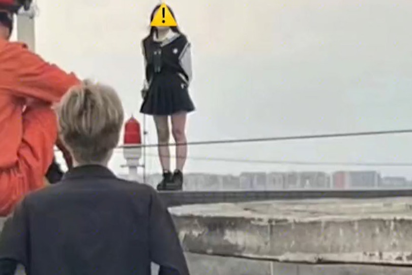 女孩疑似因情跳楼被气垫接住,目击者称她在楼顶站了大约1小时