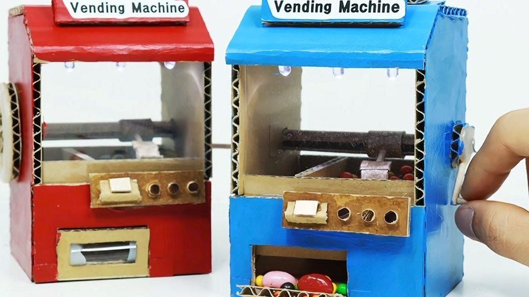 小伙用纸板制作的抓糖果娃娃机,用勺子把内部的糖果挖出来