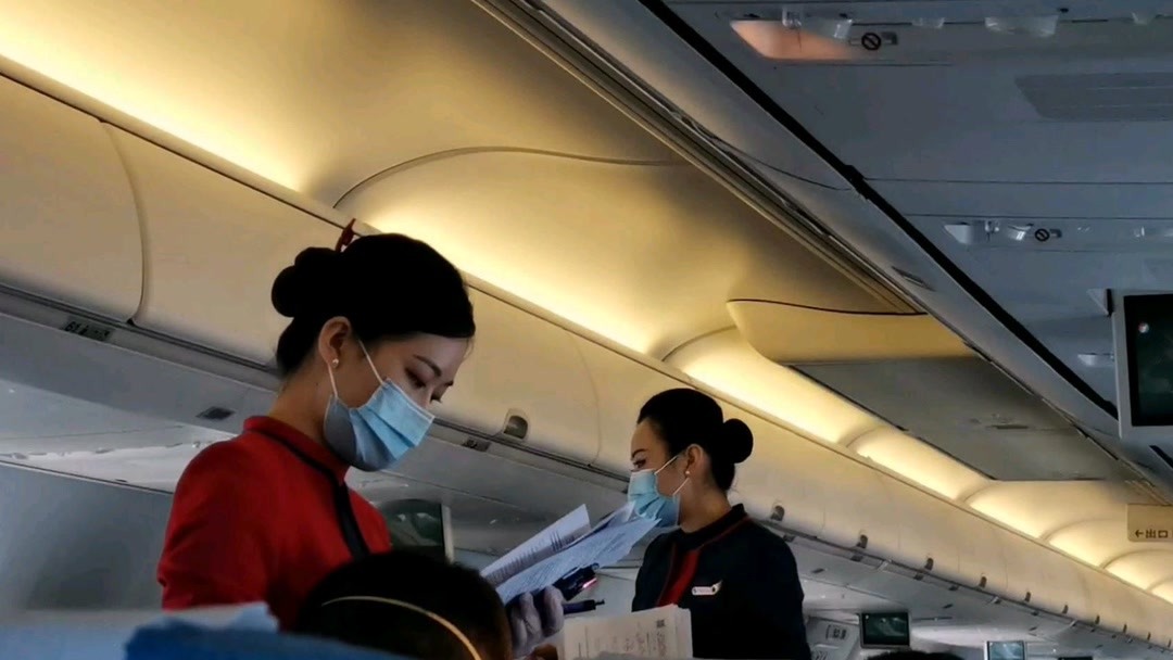 疫情期间乘坐飞机,需填写健康登记表和测体温,美女空姐忙前忙后
