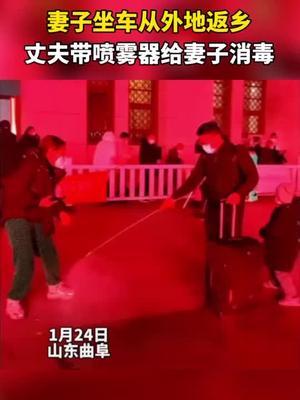 妻子从外地坐车返乡,丈夫用喷雾器为其消毒。