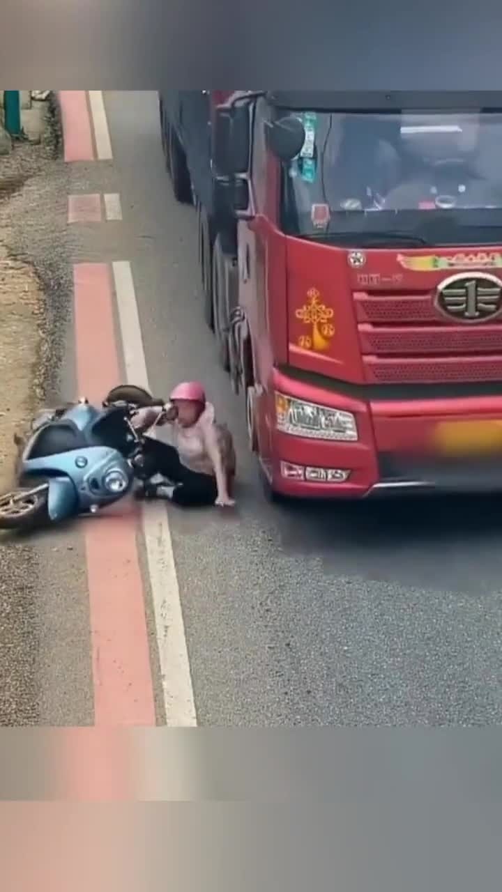 大货车超车过程中与电动车发生碰撞,骑车女子倒地后蜷缩收腿躲避逃过一劫