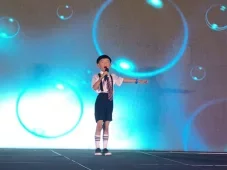 在幼儿园毕业演出舞台上演唱《让我们荡起双桨》
