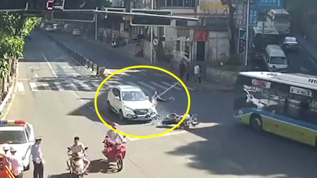 惊险!红绿灯路口抢三秒 将前方摩托车驾驶员撞飞