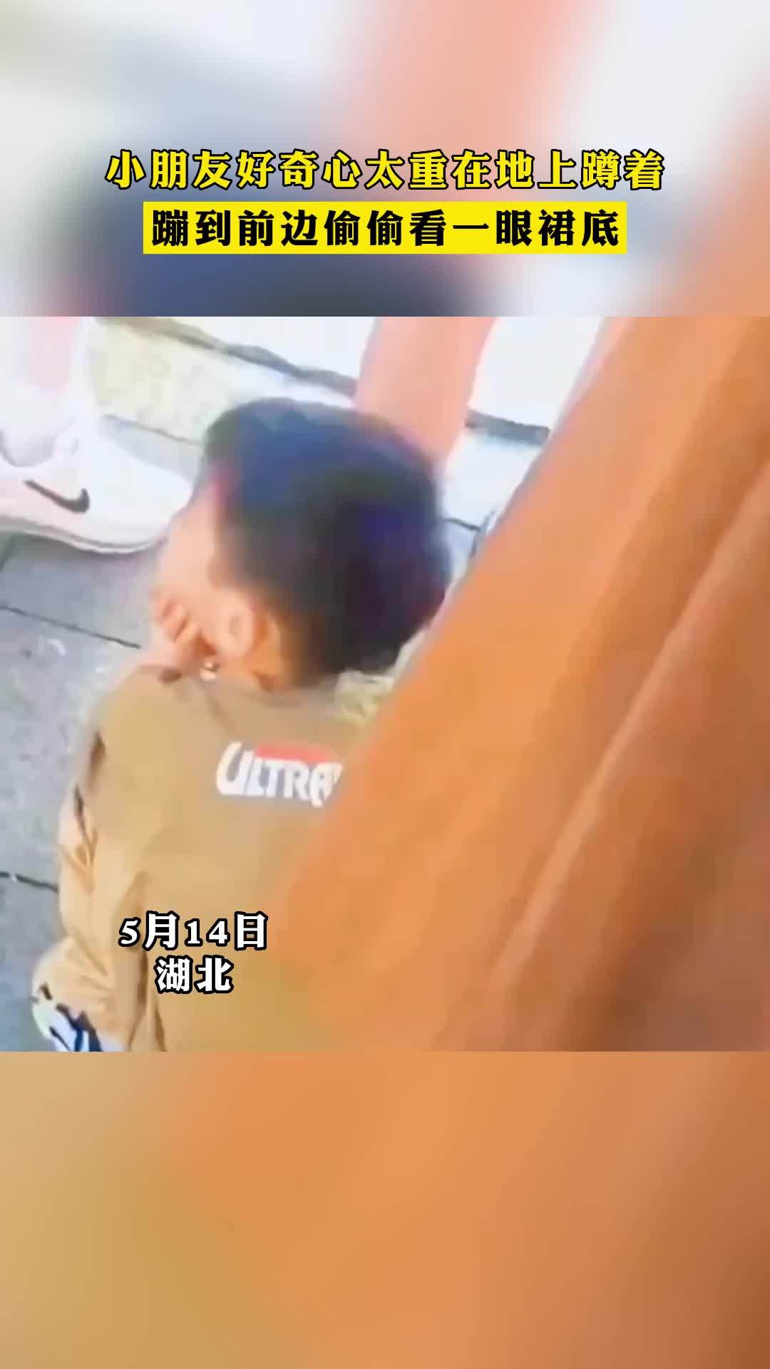小朋友好奇心太重在地上蹲着,蹦到前边偷偷看一眼裙底