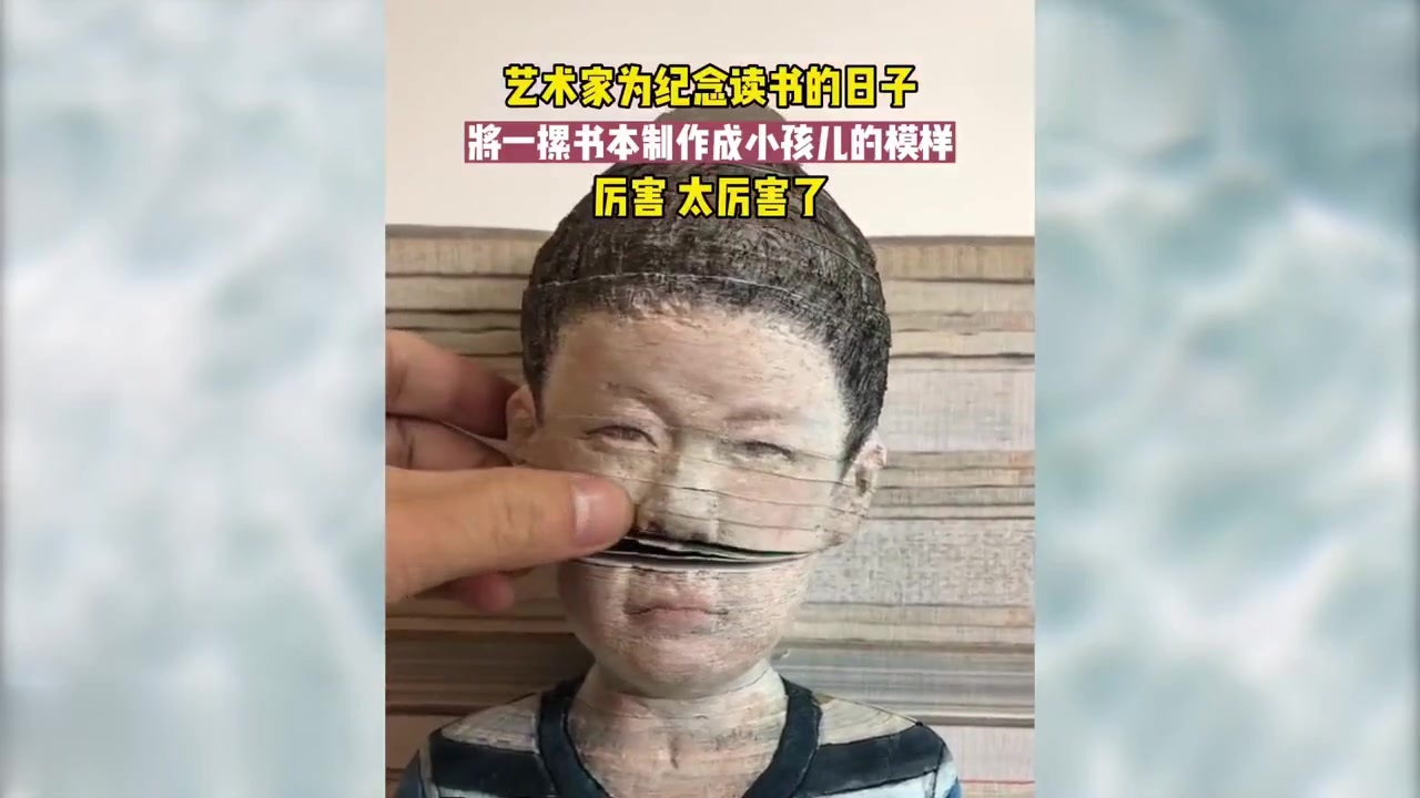 艺术家为纪念读书的日子,将一摞书本制作成小孩儿的模样