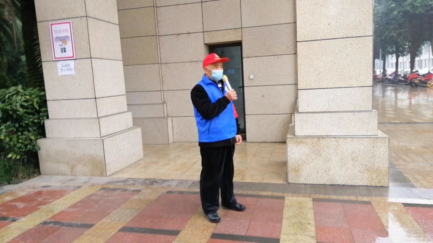 疫情期间,一位老年志愿者在小区门口宣传抗疫知识,宣扬爱国精神