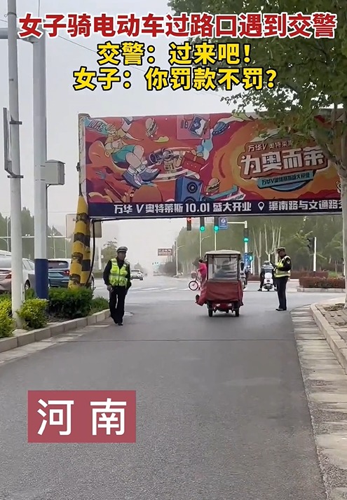 女子骑电动车过路口遇到交警,女子:你罚款不罚 交警:听不清楚,我过来.