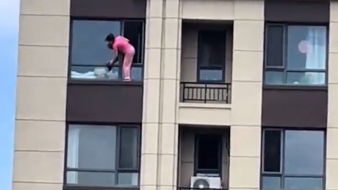 女子站在30多层高楼窗外徒手擦玻璃 目击者:没有任何安全保护措施