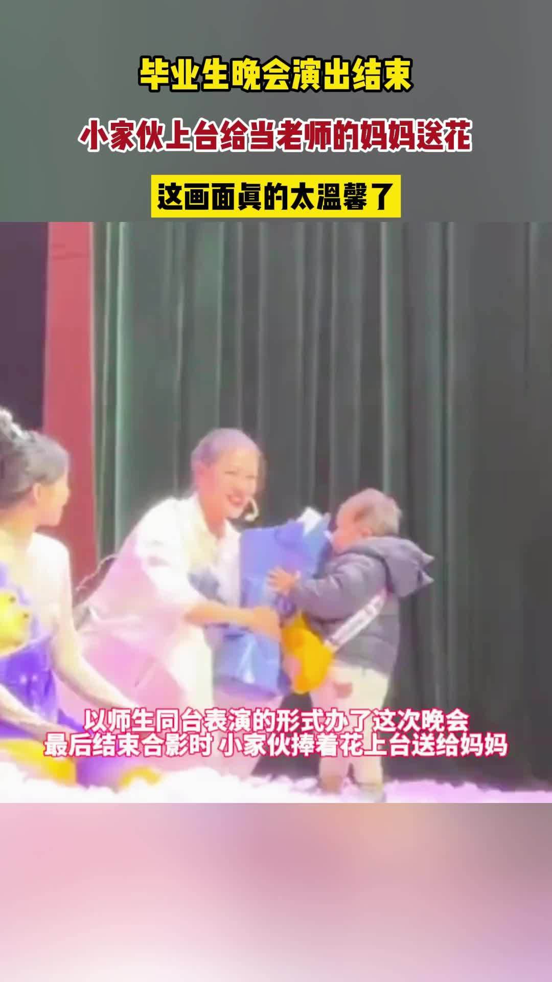 毕业生晚会演出结束,小家伙上台给当老师的妈妈送花。