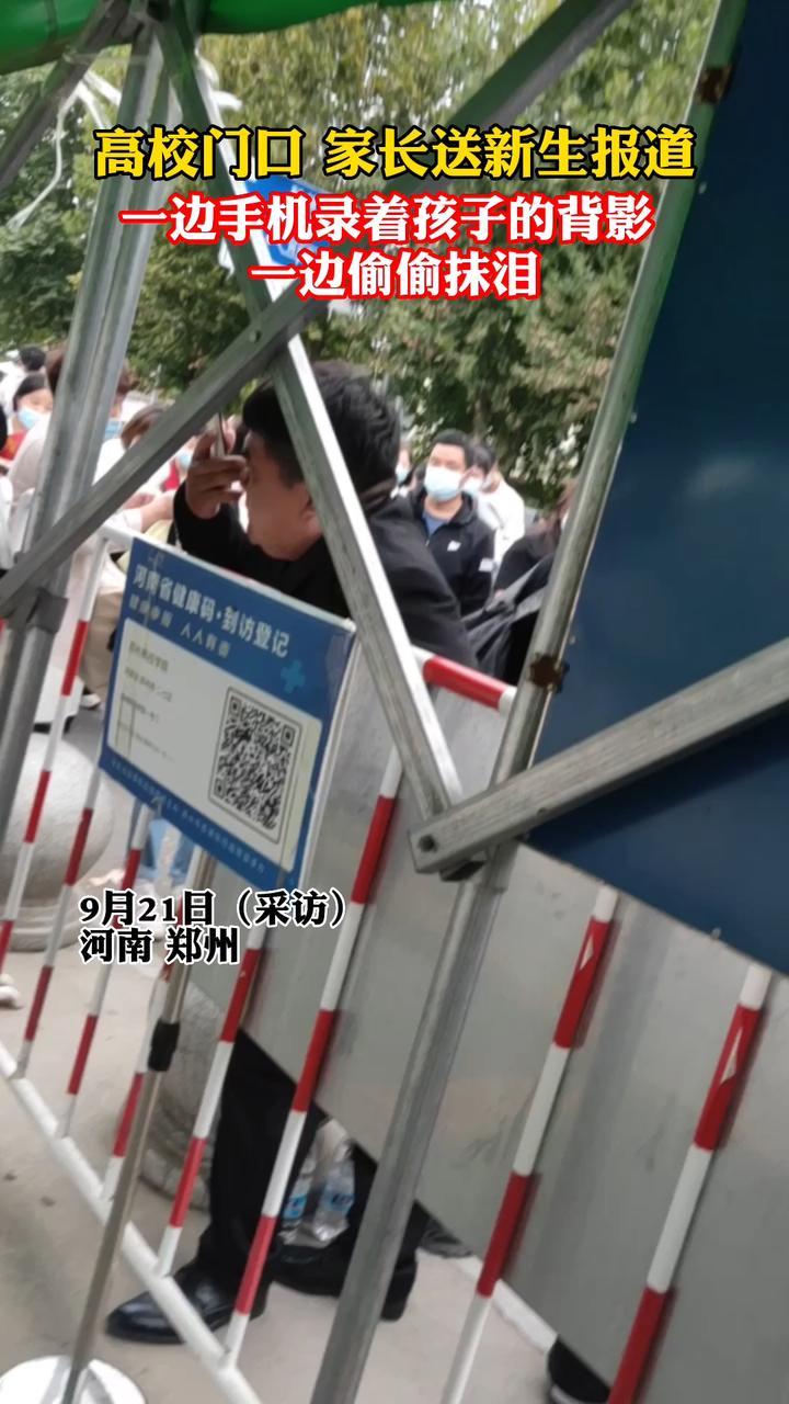 9月21日,郑州一高校门口,家长送新生报道。孩子进入学校后,家长久久...