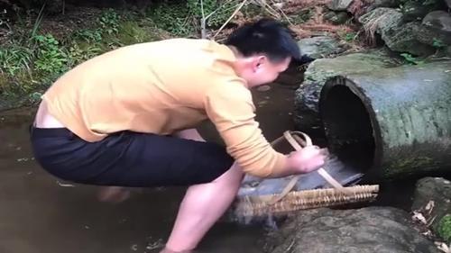小伙子为了吃鱼太拼了,钻进排水管里抓鱼,真不容易!