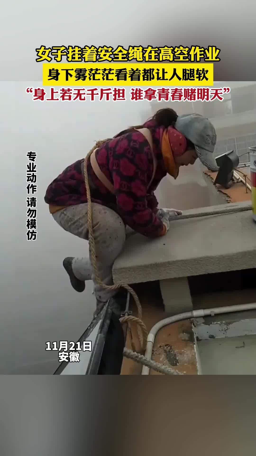 女子挂着安全绳在高空作业,身下雾茫茫看着都让人腿软