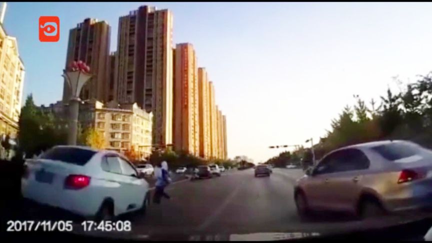 实拍两学生横穿马路 被赶红灯轿车撞飞