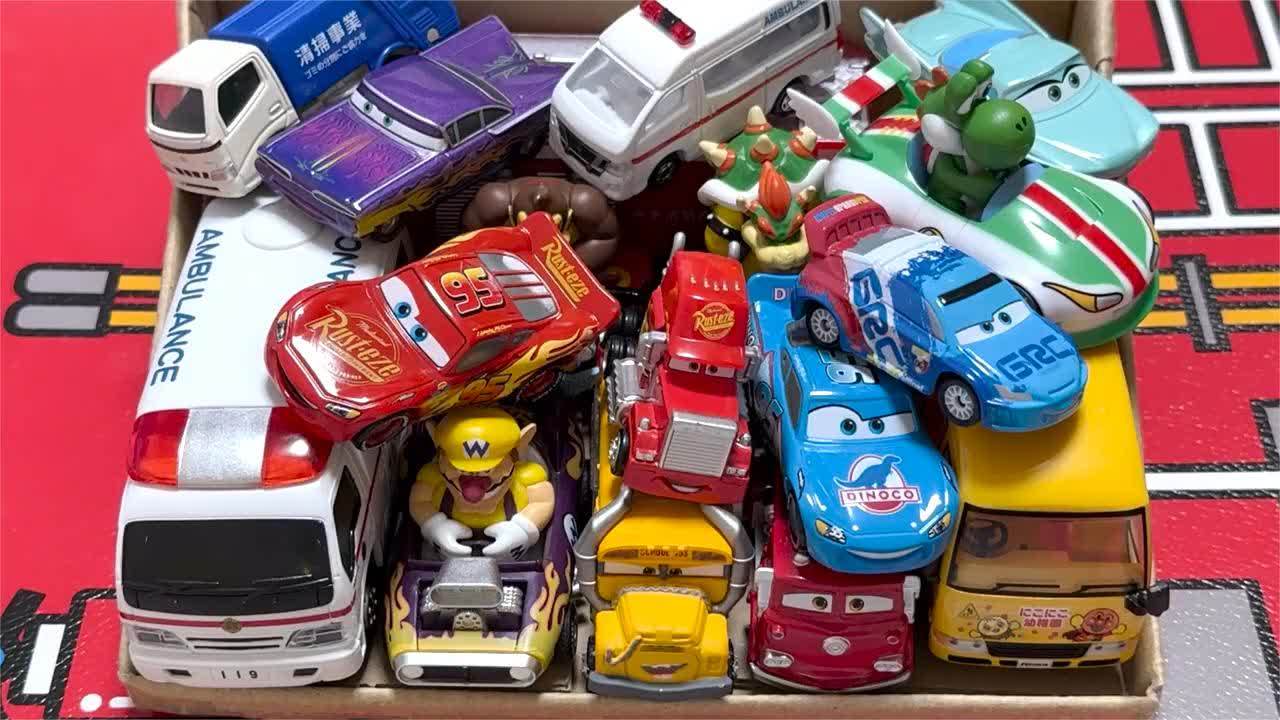 小男孩喜欢的赛车总动员玩具小汽车在纸箱上拆箱展示滑行的游戏