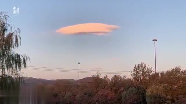 北京朝霞现玫瑰色荚状云,外形似飞碟