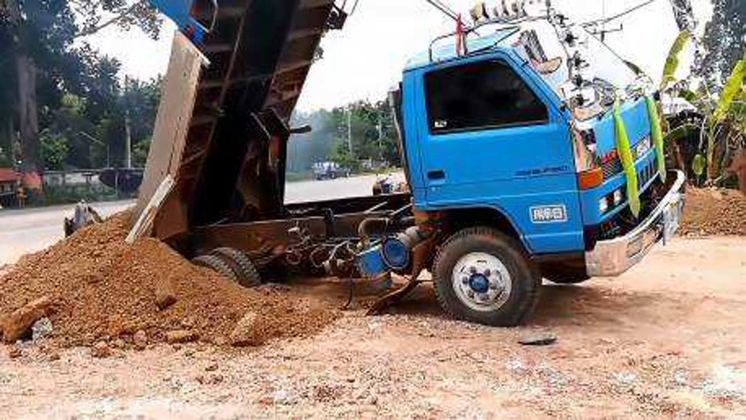 国外实拍:翻斗车这趟活算是白干,后轮陷坑里,车厢板也被砸坏了