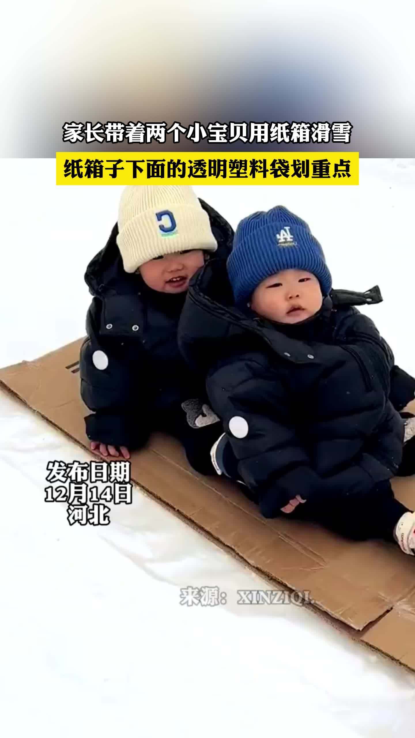 家长带着两个小宝贝用纸箱滑雪,纸箱子下面的透明塑料袋划重点