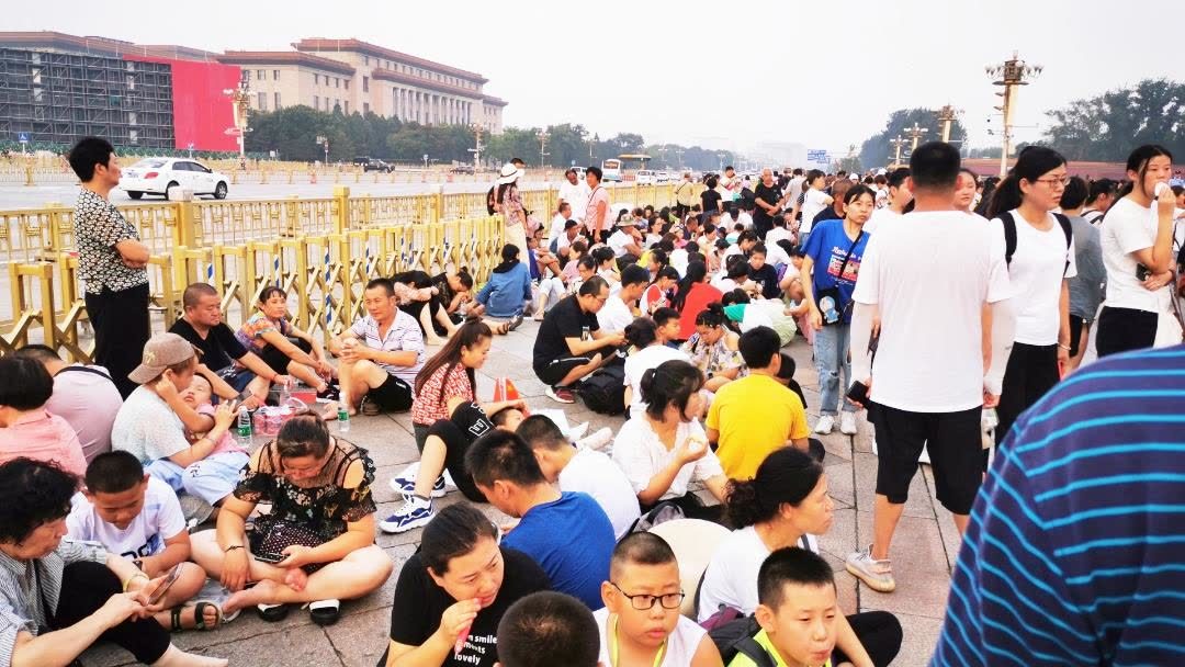北京天安门广场升旗后,城楼前坐了很多人,等待进入天安门里面