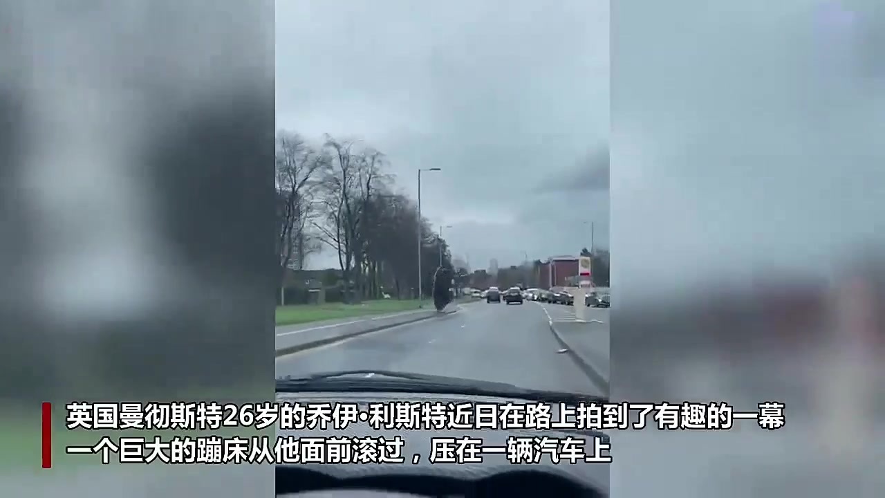 英国一名司机拍到蹦床从面前滚过压住路边一辆汽车