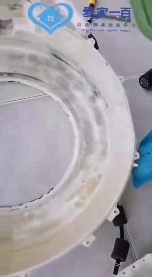 爱家一百家政服务人员正在客户家拆洗滚筒洗衣机。