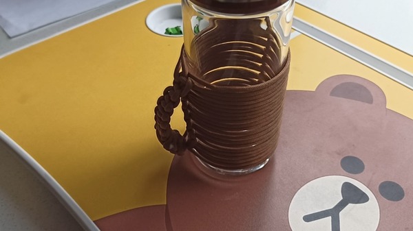 用伞绳给玻璃杯编织杯套。