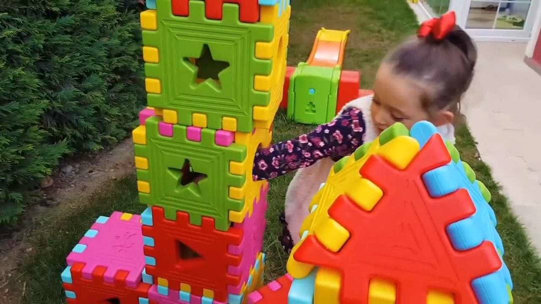 小女孩用积木拼搭了城堡的一面墙