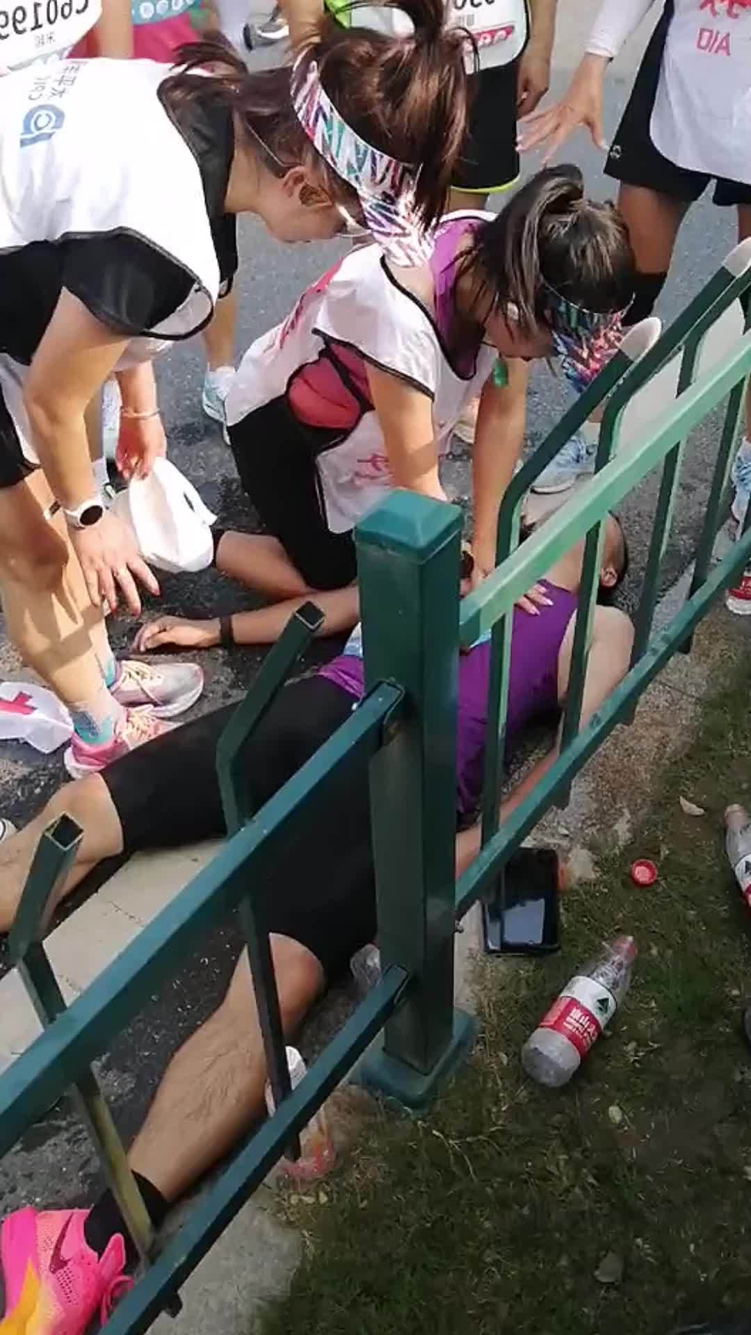 马拉松参赛者在跑步途中昏倒,志愿者轮流为他做心肺复苏