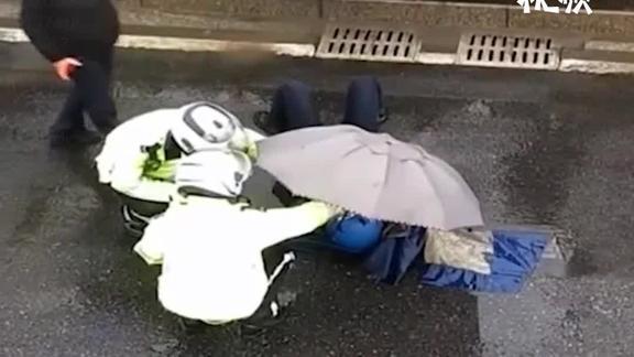 暖心!杭州一电动车驾驶员被撞到无法动弹,交警奔赴而来为其打伞