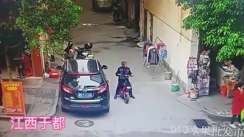 一名老人驾驶电动自行车来到路口,小汽车倒车未注意观察周边情况,辗...