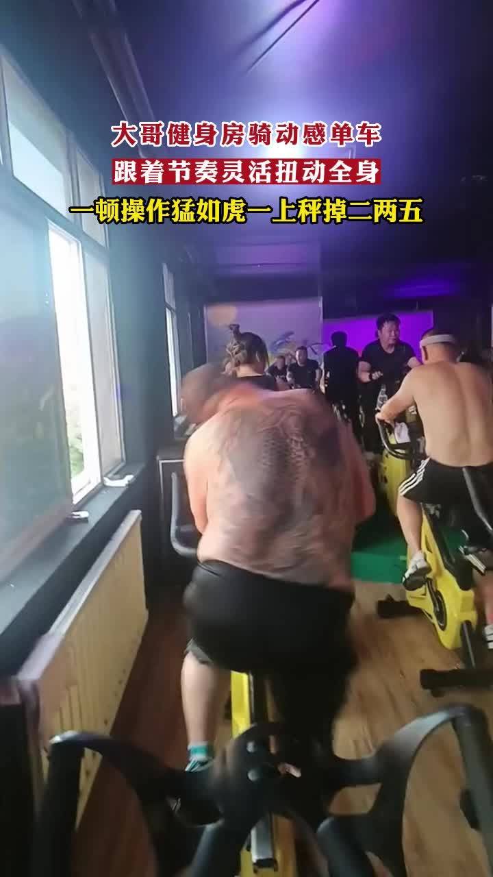 大哥健身房骑动感单车 跟着节奏灵活扭动全身