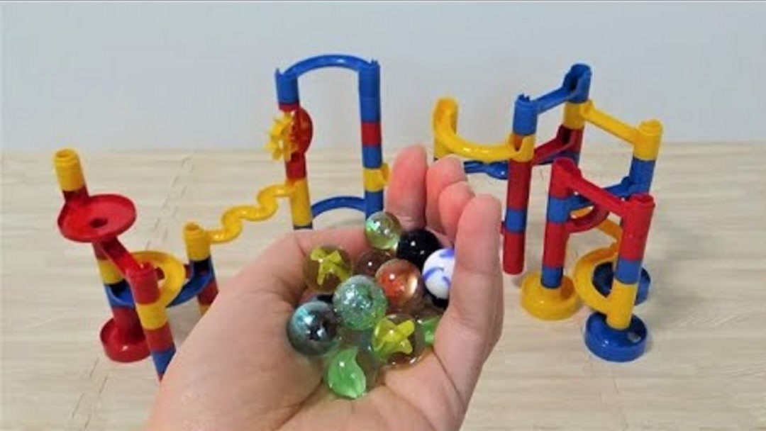 彩色玻璃球在拼搭的环形轨道上滚动