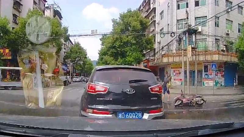路面湿水太滑,电动车男子过马路直接滑到,SUV差一点要倒霉