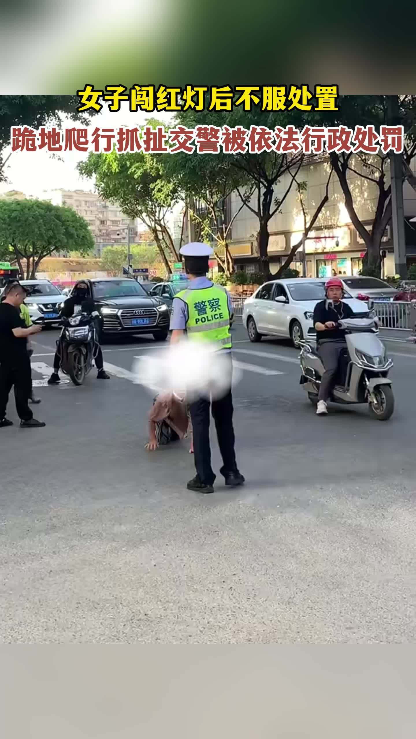 女子闯红灯后不服处置,跪地爬行抓扯交警,被依法行政处罚