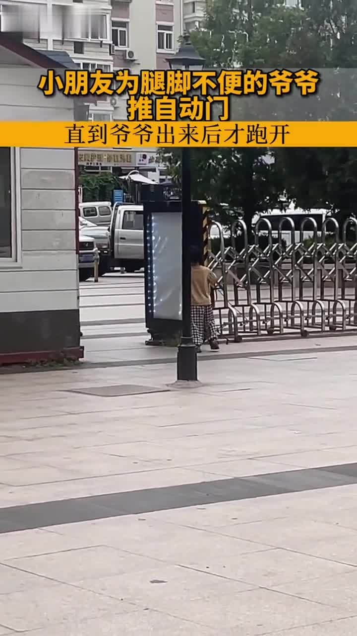 8月27日,小朋友为腿脚不便的爷爷,推自动门,直到爷爷出来后才跑开。