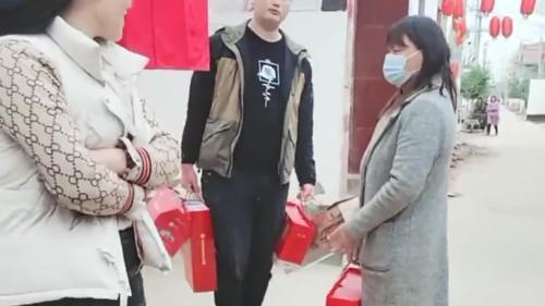 小伟在门口等媳妇开车过来回城,手里还拎了好多的礼品,难道去看丈母娘