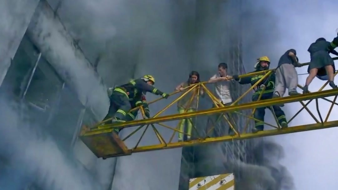 逃出生天:消防员借来起重机的吊臂,要用吊臂营救被困在楼里的人