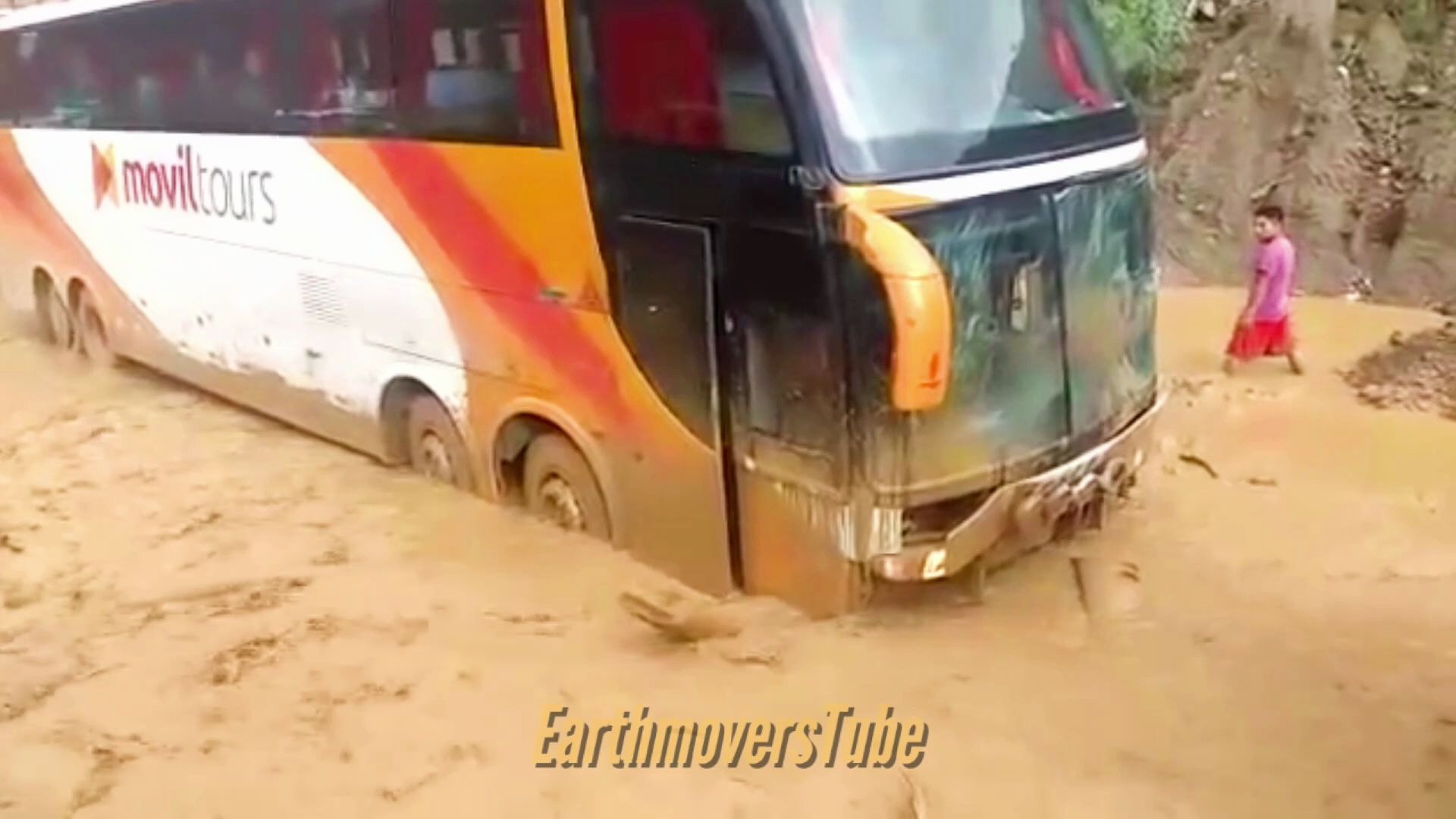 危险驾驶公共汽车穿越泥泞的道路和洪水泛滥的河流