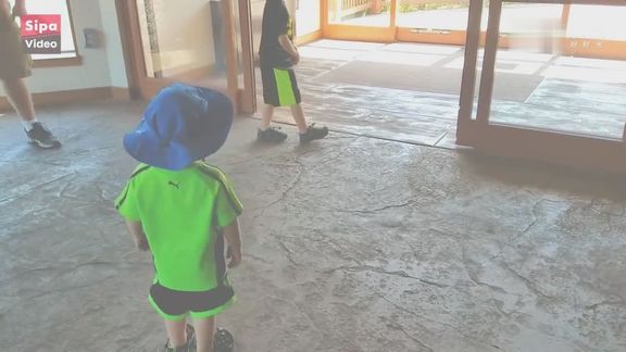 可爱逗趣的孩子在自动推拉门面前演绎着巫师般的技能