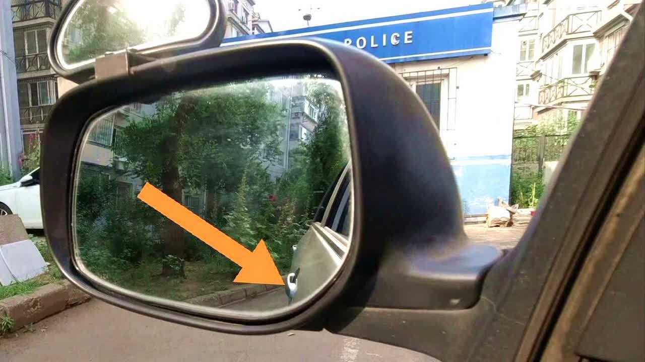 倒车退行,靠路边停车,在后视镜中寻找定位